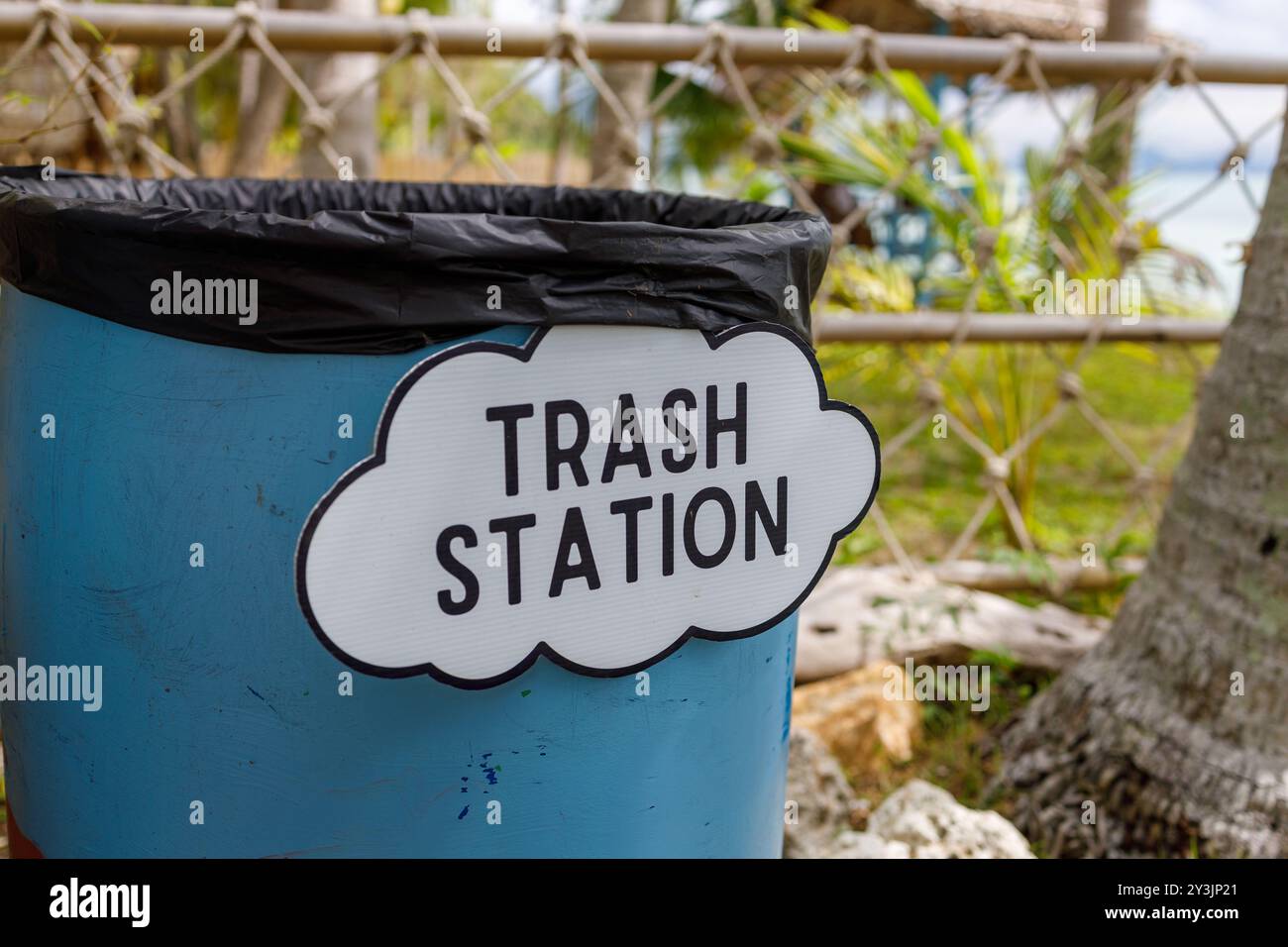 A close-up of a blue trash bin labeled "Trash Station" with a cloud ...
