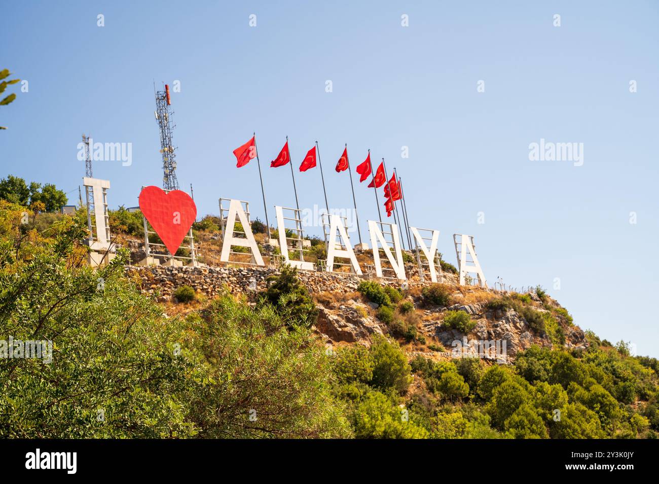 Panoramic view of the 'I Love Alanya' sign with Turkish flags waving ...
