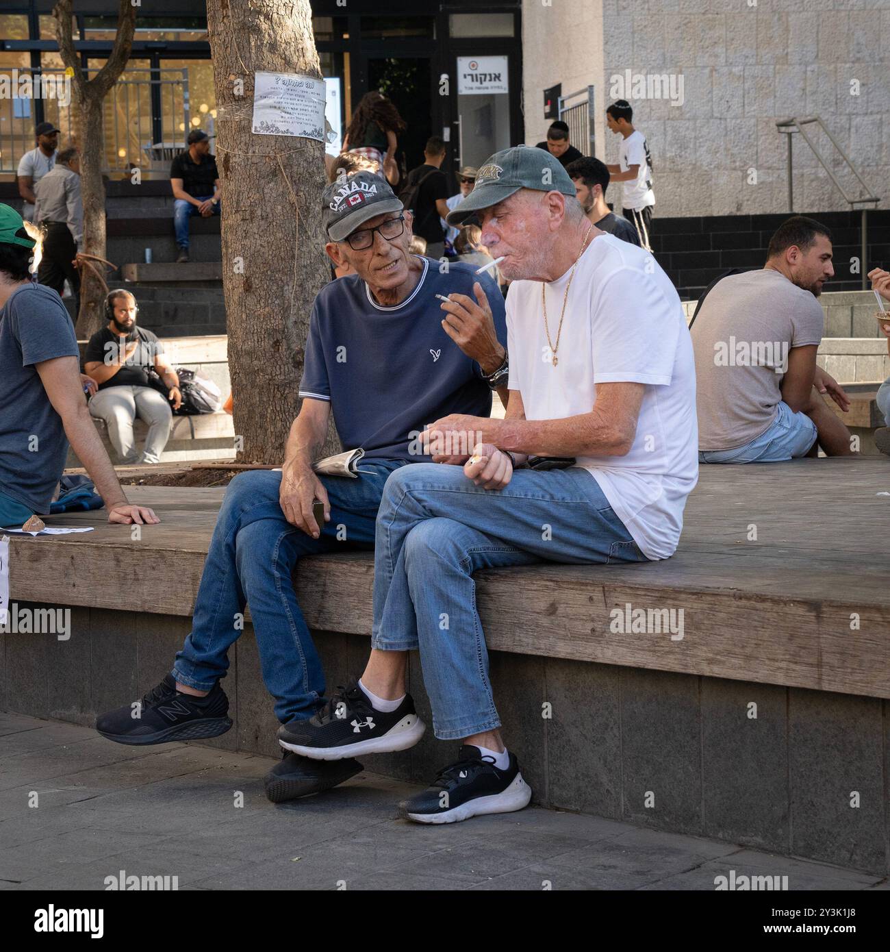 Jerusalem, Israel - July 18th, 2024: Two men sitting on a bench in the ...