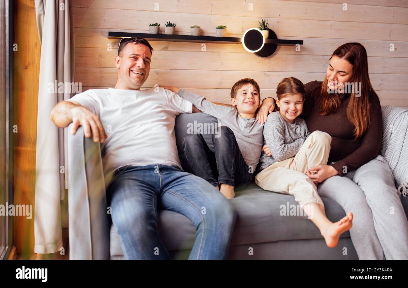 Young happy family is relaxing at home. Little children and their ...