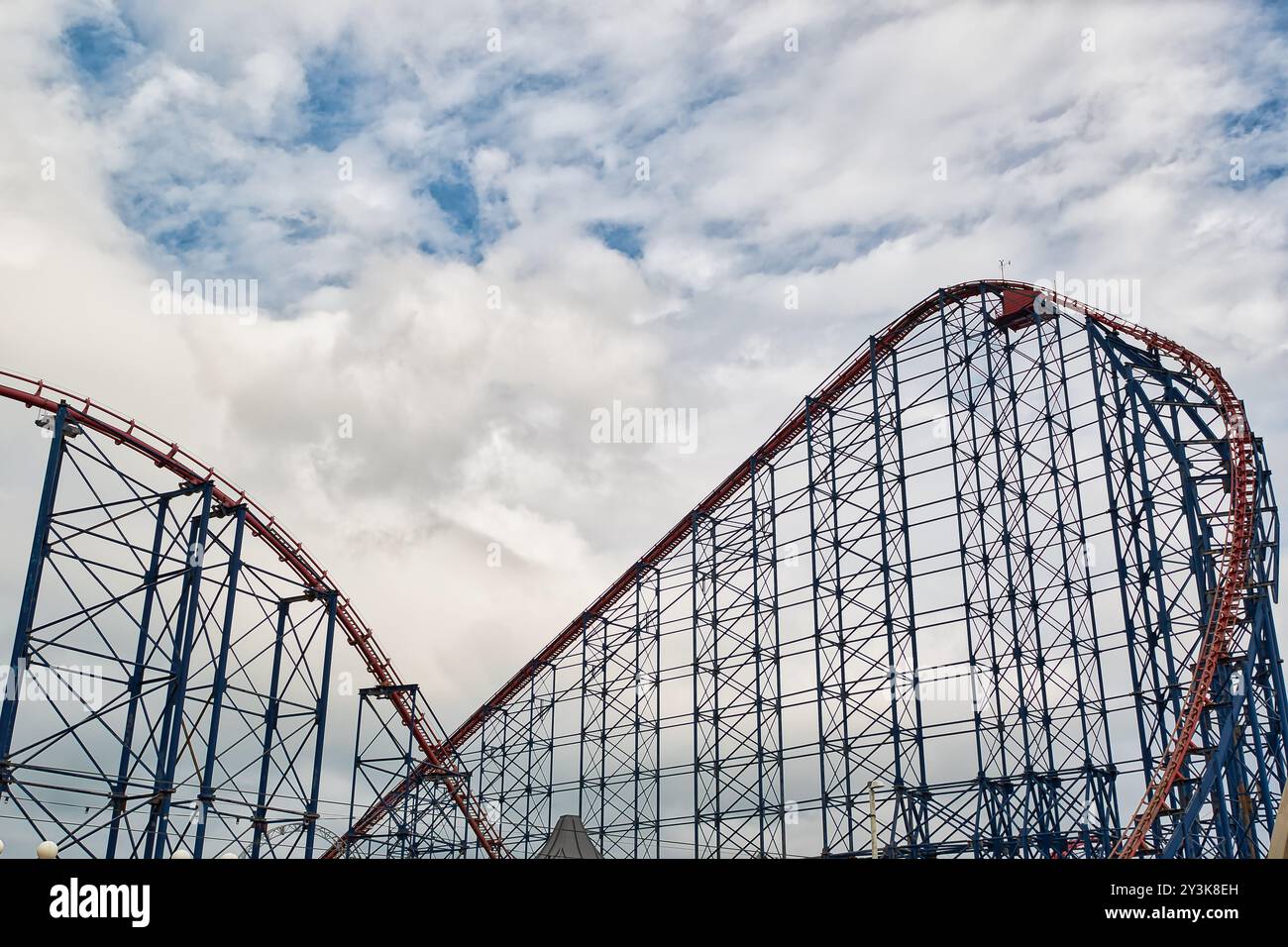A towering roller coaster with a red and blue structure against a ...