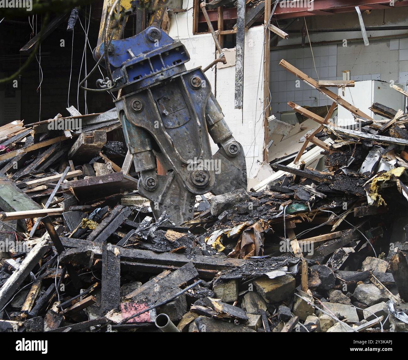 A demolition shear working on dismantling a destroyed house Stock Photo ...