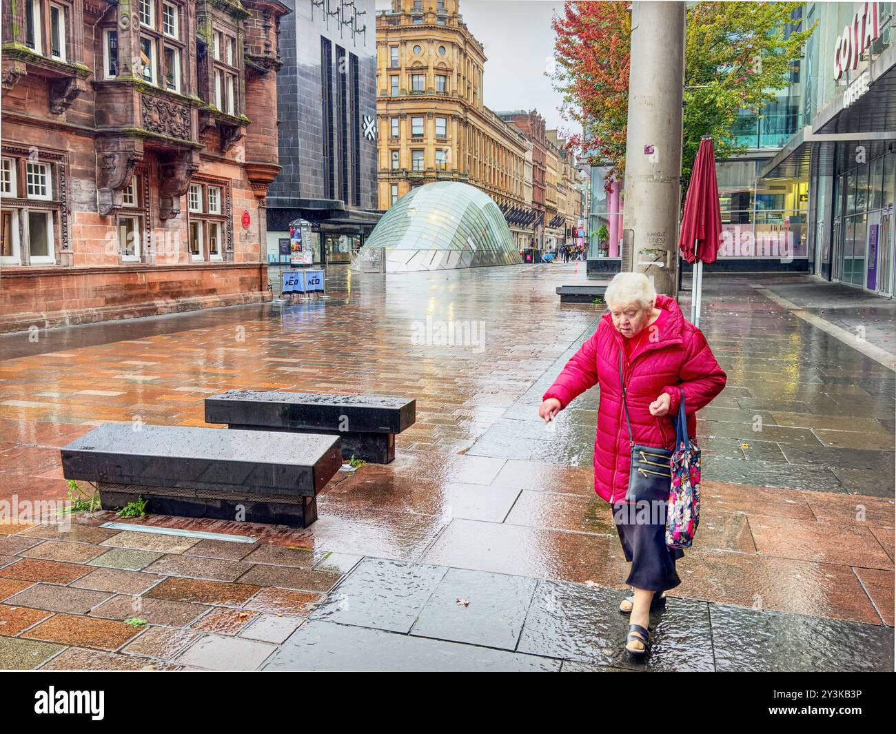 Elderly lady walking during wet weather in the city Stock Photo - Alamy