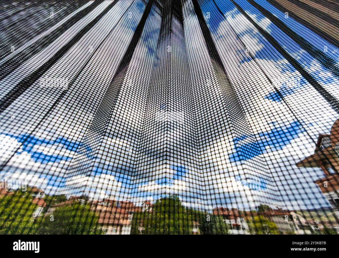 Distorted View: Clouds and Neighborhood Through Mesh Window Frame Stock ...