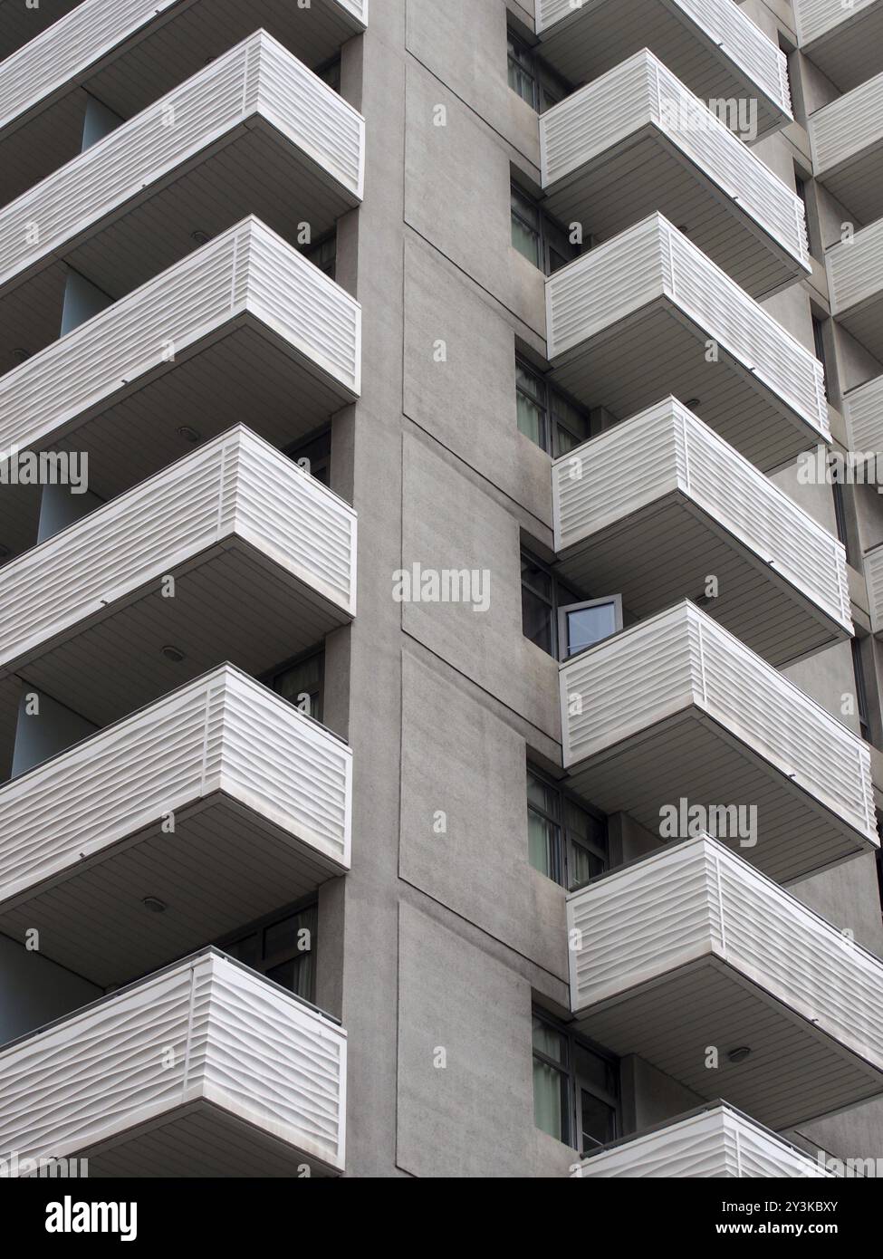 Modern white concrete apartment block with geometric angular balconies ...
