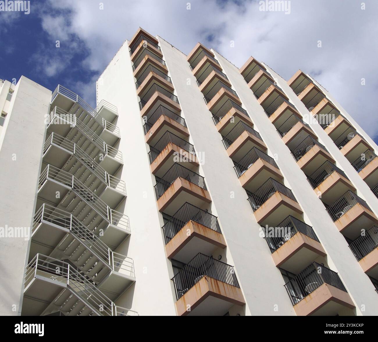Angled detail view of an old 1960s white concrete apartment building ...