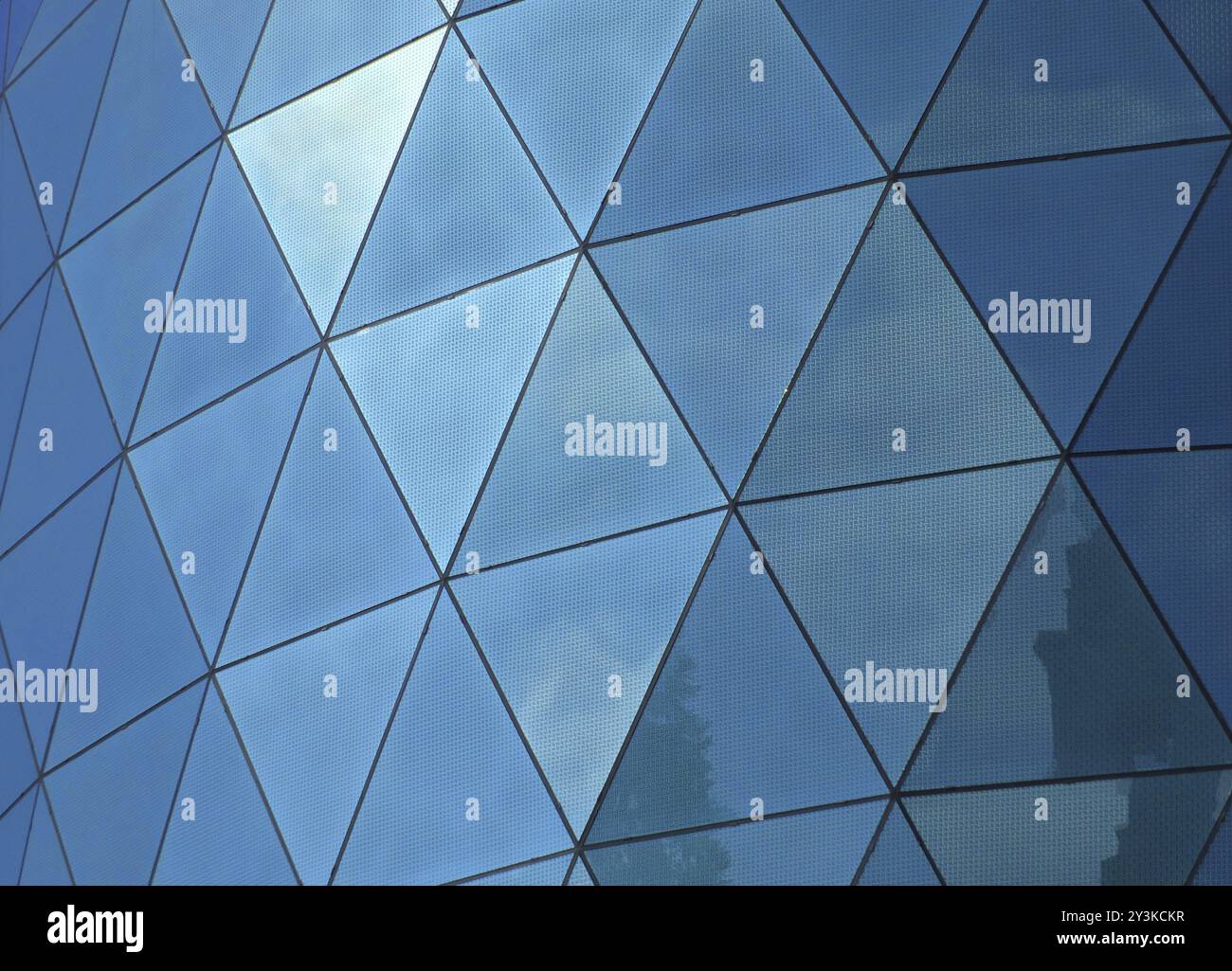 Angular patterned mirrored windows panes reflecting the sky and clouds ...