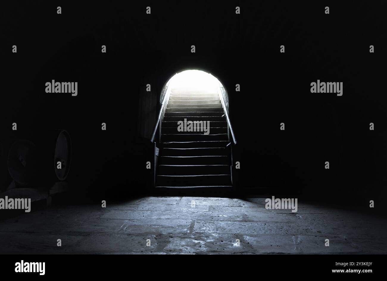 Medieval basement in complete darkness with a strong light at the exit ...
