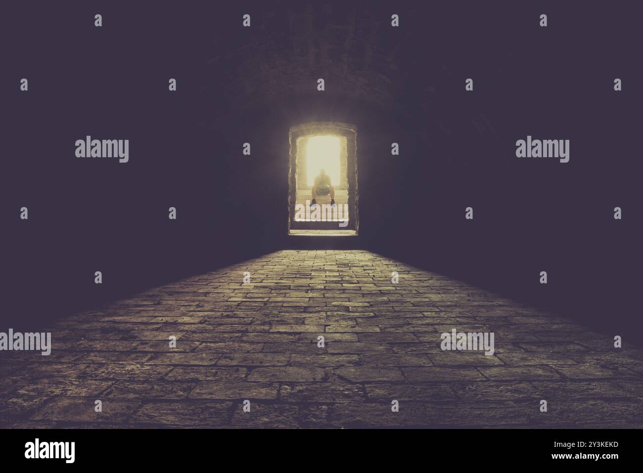 Inside view from a medieval basement with a man sitting on the stone ...