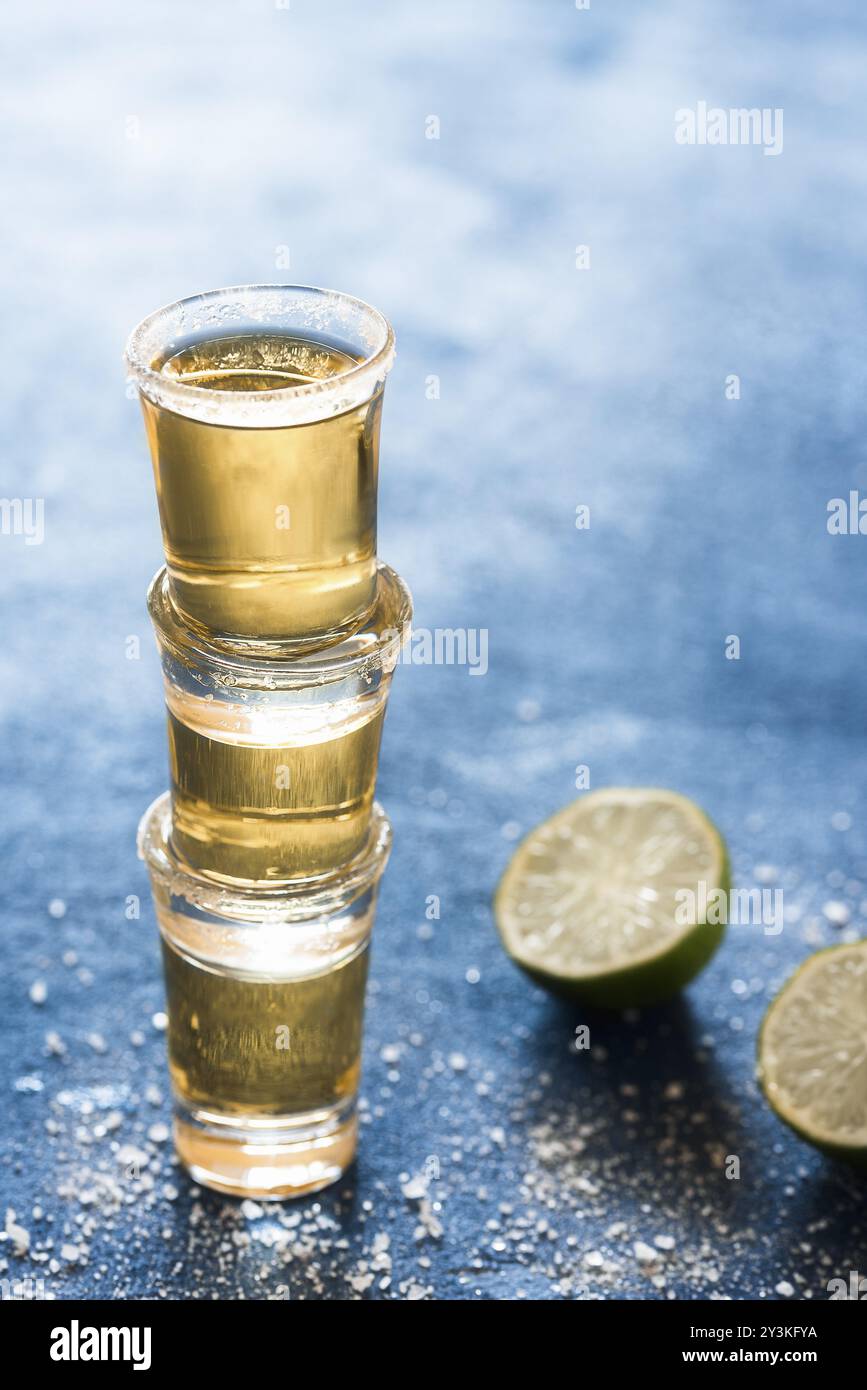 Three shots of tequila stacked, on a blue table. Gold tequila glass ...