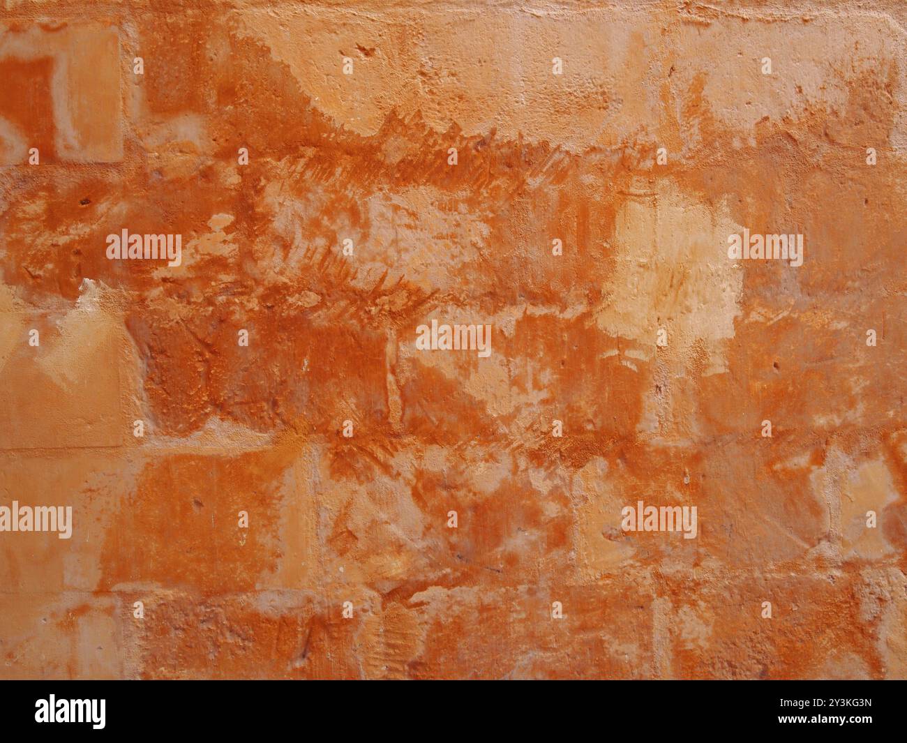 An old distressed patched orange stone wall painted in different shades ...