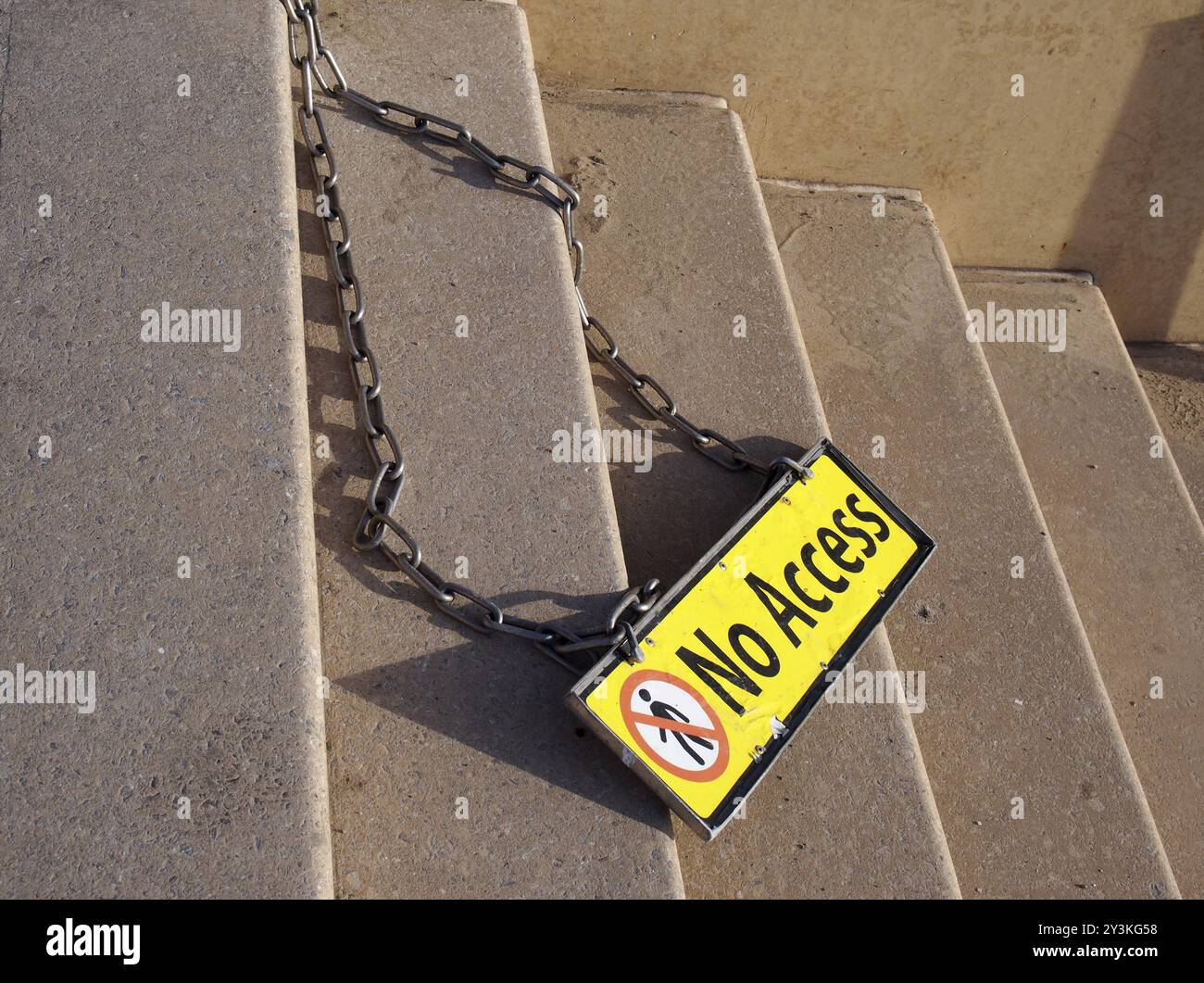 Yellow metal no access sign on a chain on concrete steps with no ...