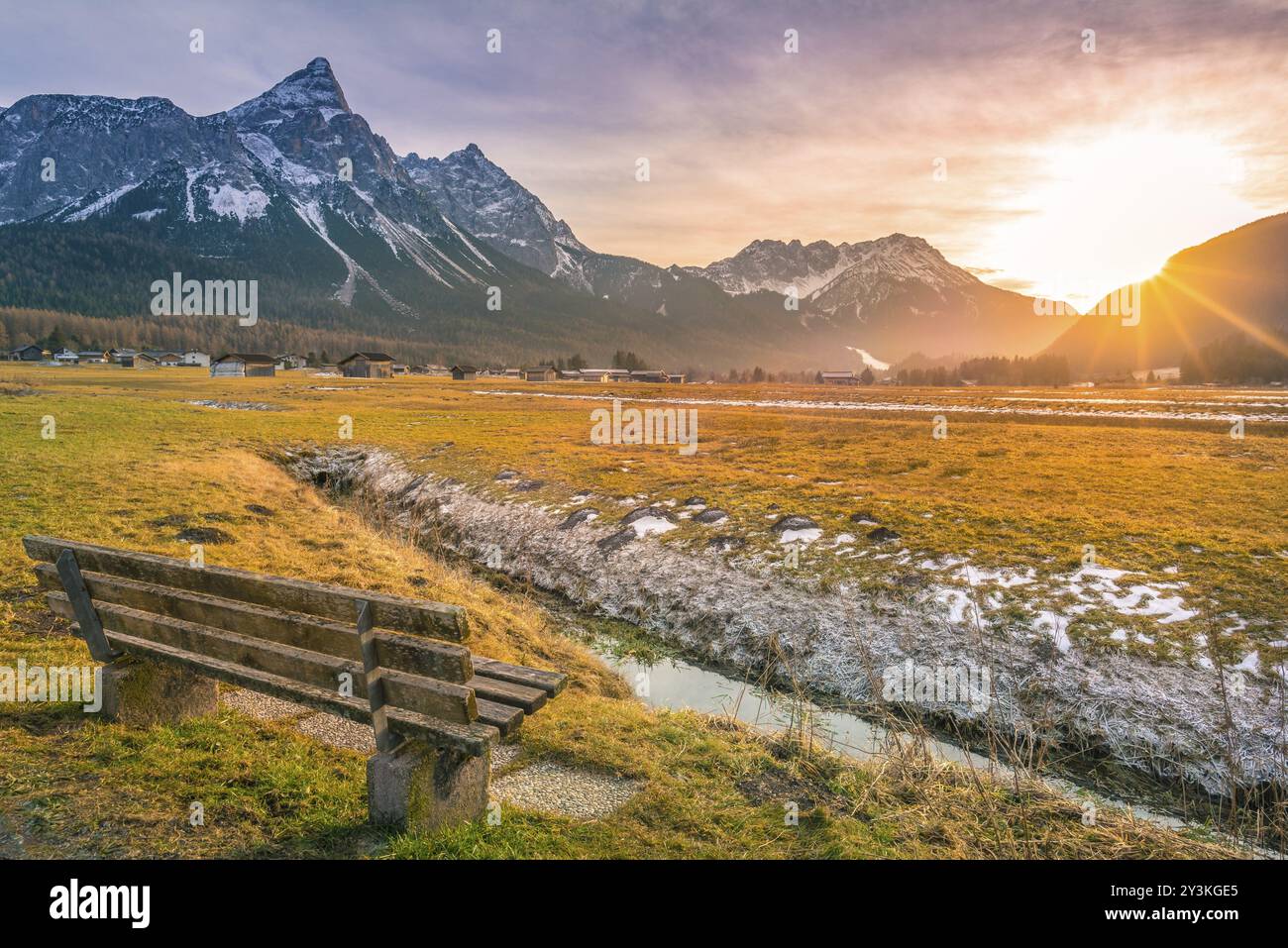 Charming winter scenery with a wooden bench on the side of a small ...