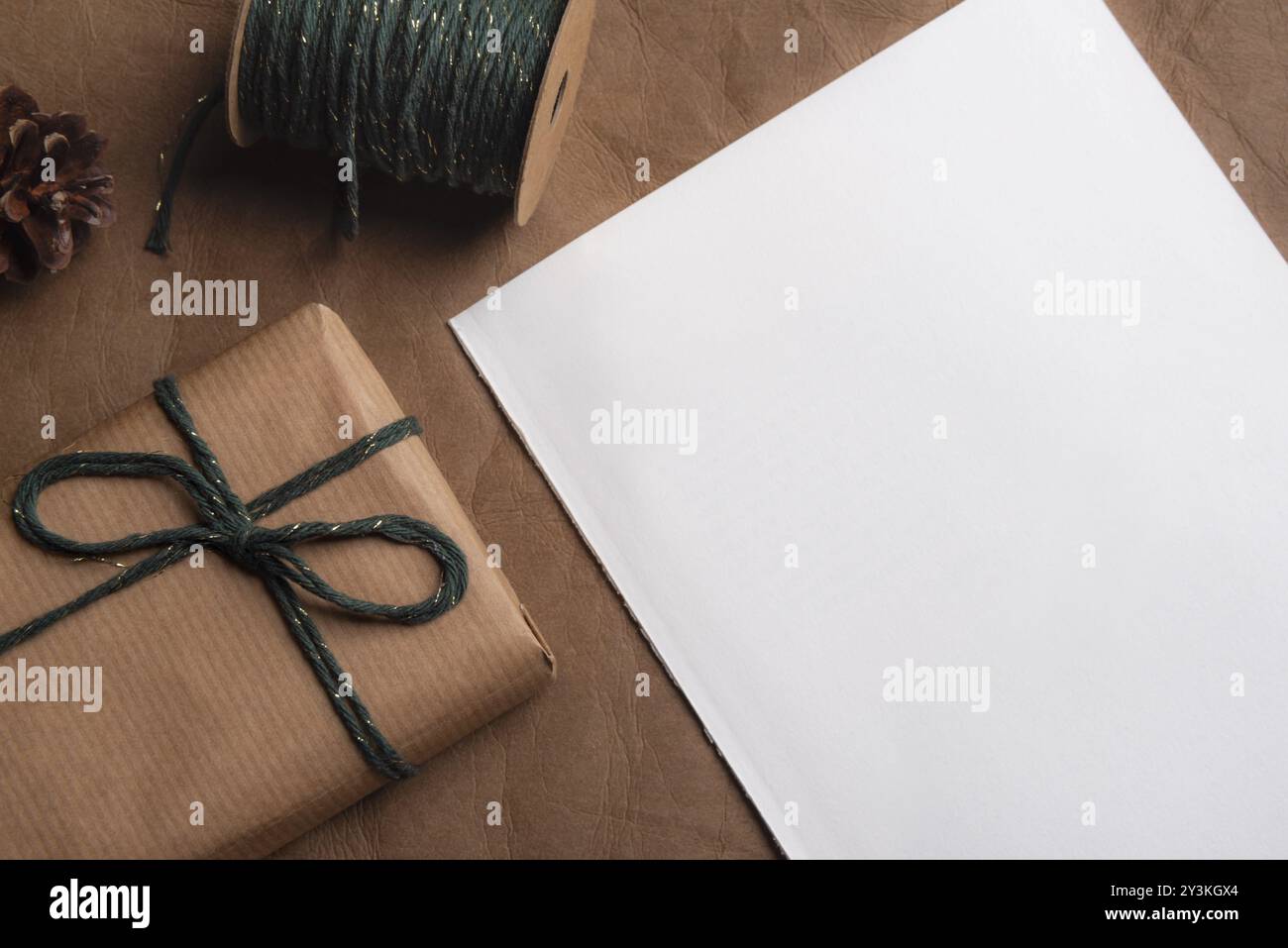 Gift box wrapped in classic brown paper, tied with green and gold ...
