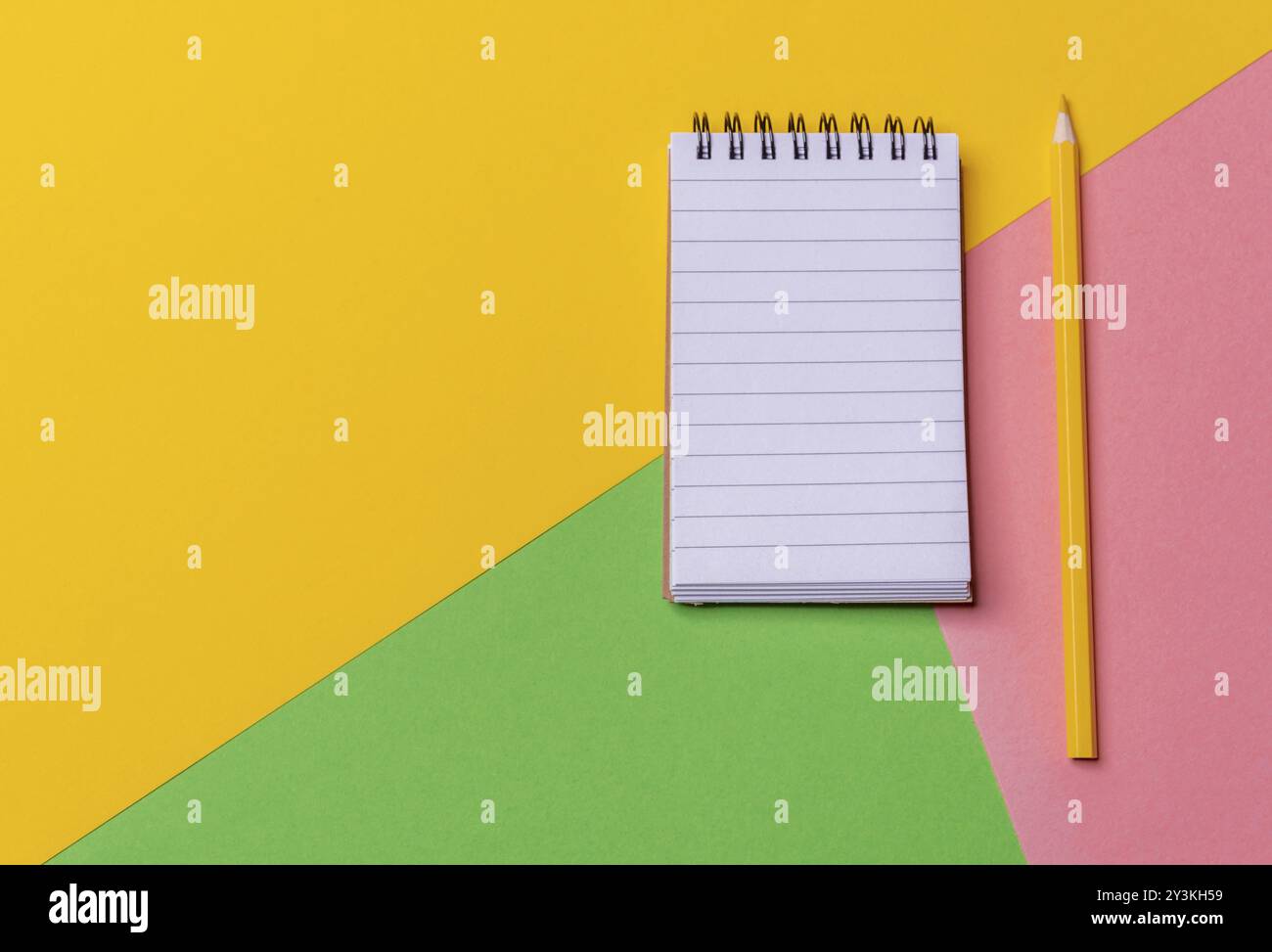 Above view of an office desk in three colors with an empty spiral ...