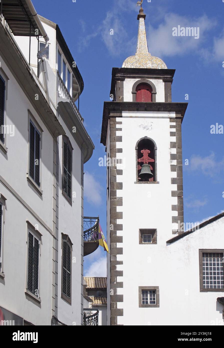A street of old white painted houses and the tower of the historic ...