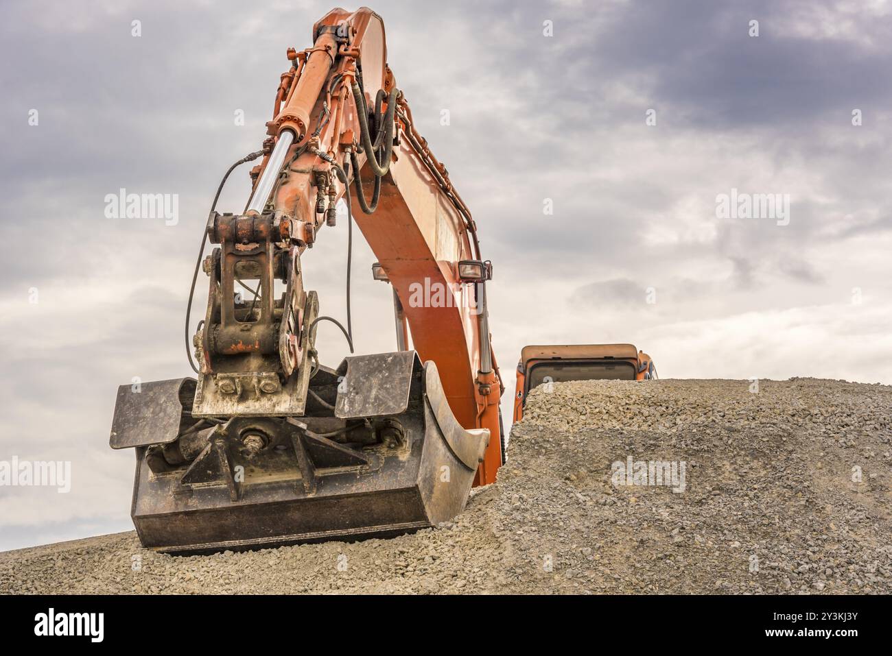 Frontal close up with the bucket and arm from a big orange excavator ...