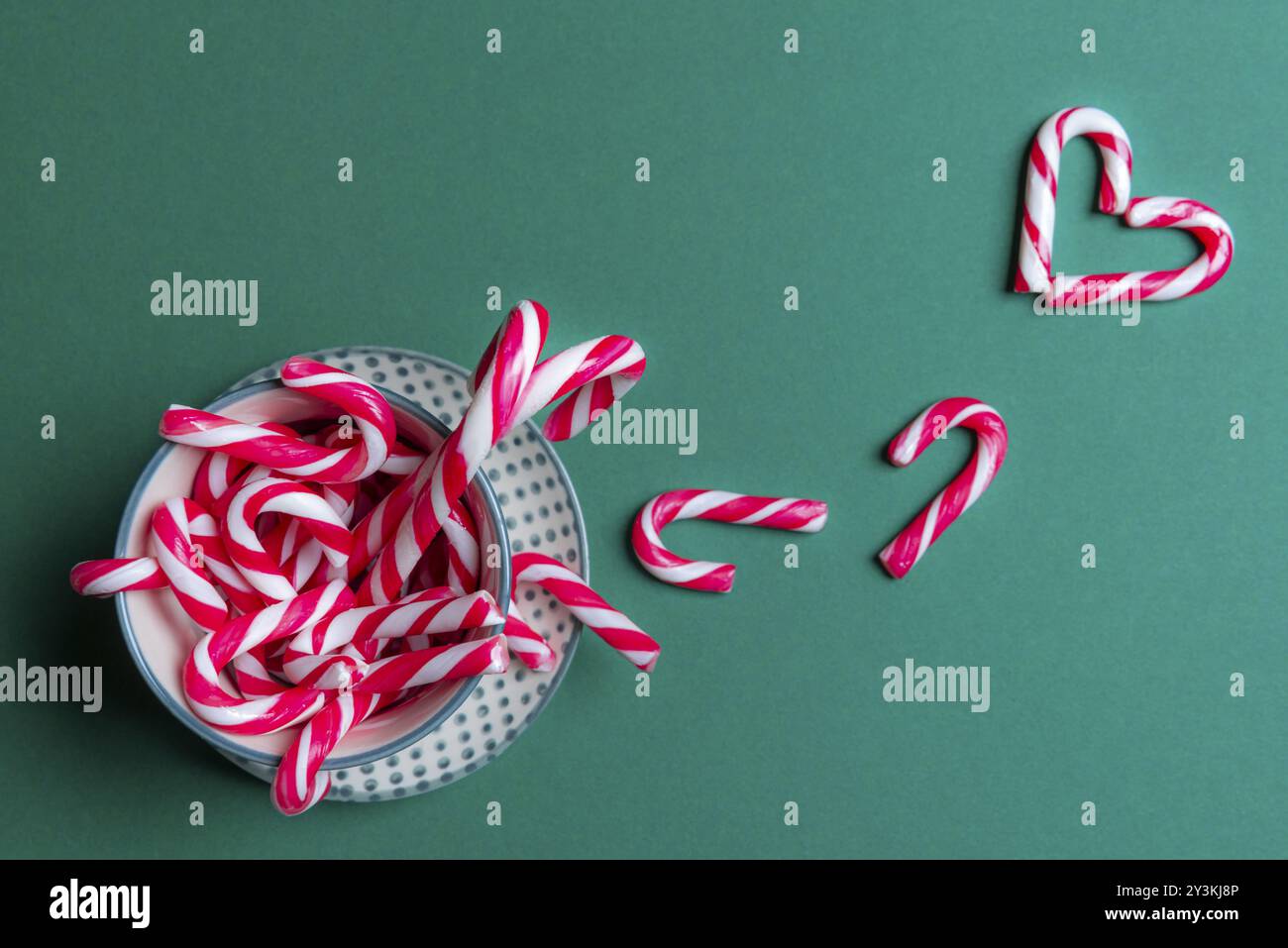 Coffee cup full of mini candy canes with red-white stripes, and a few ...