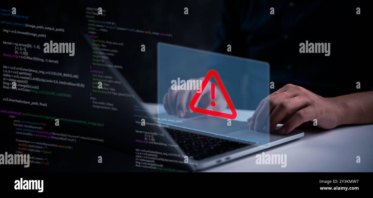 Hands typing on a laptop keyboard with a red warning symbol displayed on a virtual interface ...