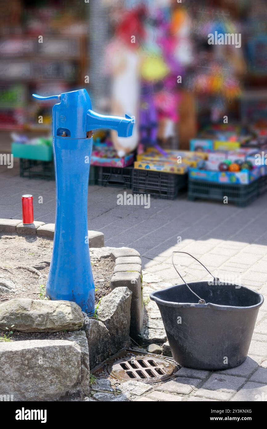A blue water pump on a pedestrian street with a water pump next to it ...
