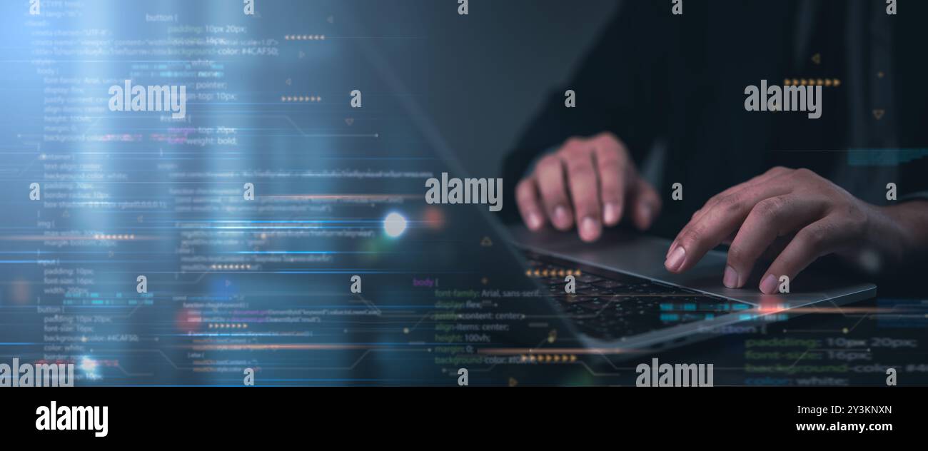 Hands typing on laptop with programming code on screen, representing software development ...