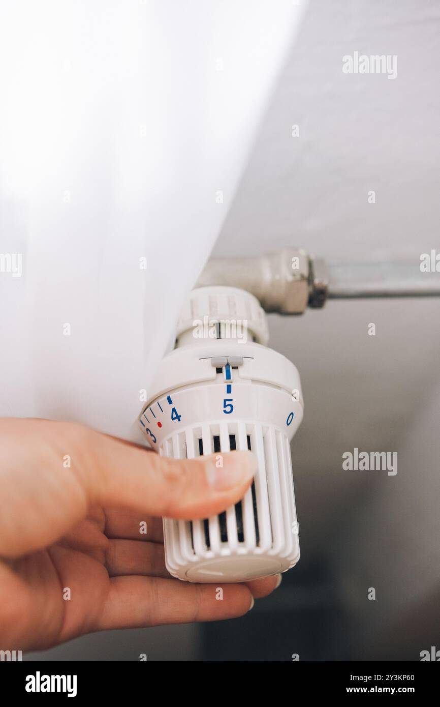 Hand turns the battery heating knob Stock Photo - Alamy