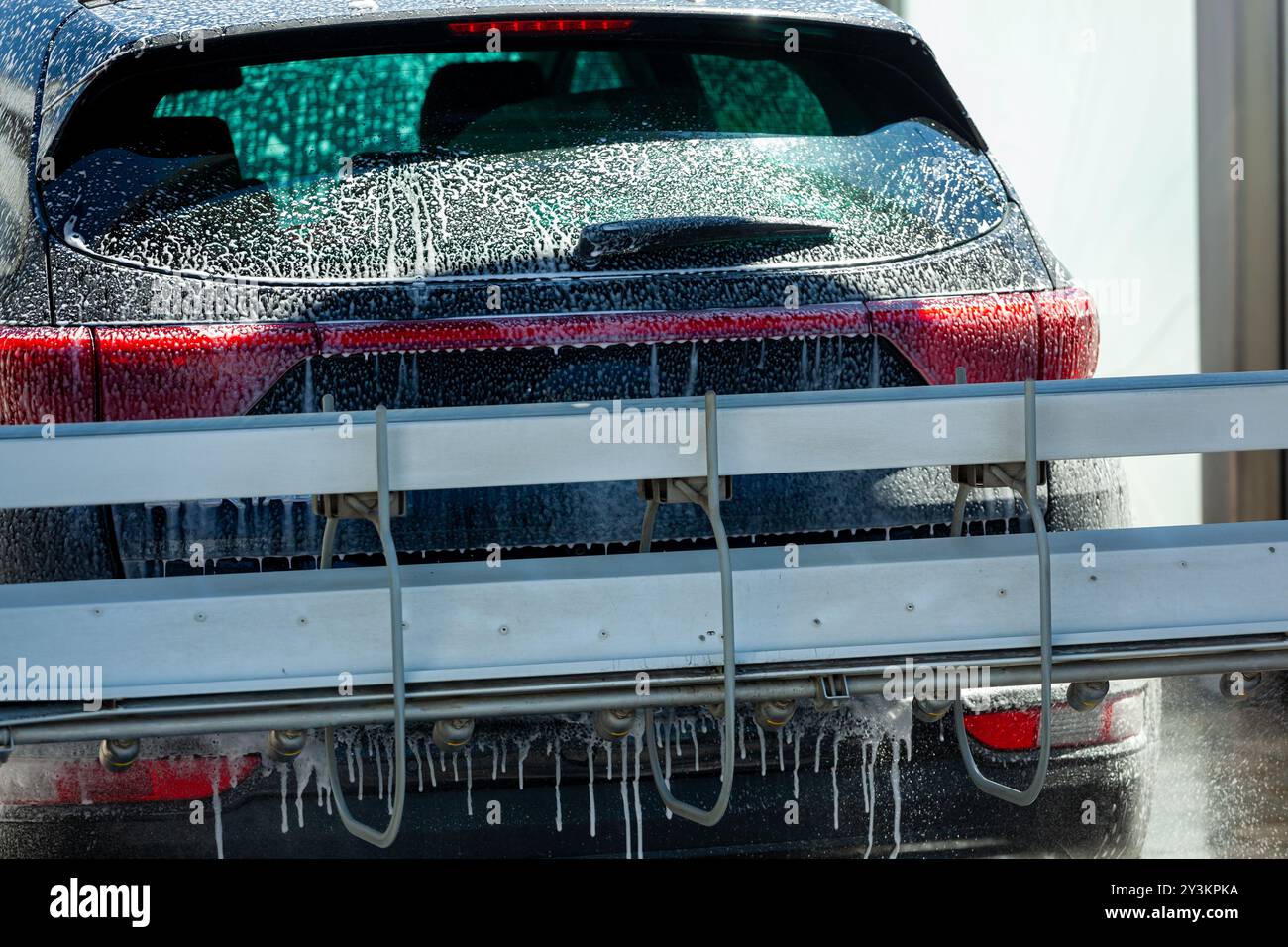 Contemporary vehicle cleaning system applies soapy suds to the rear of ...