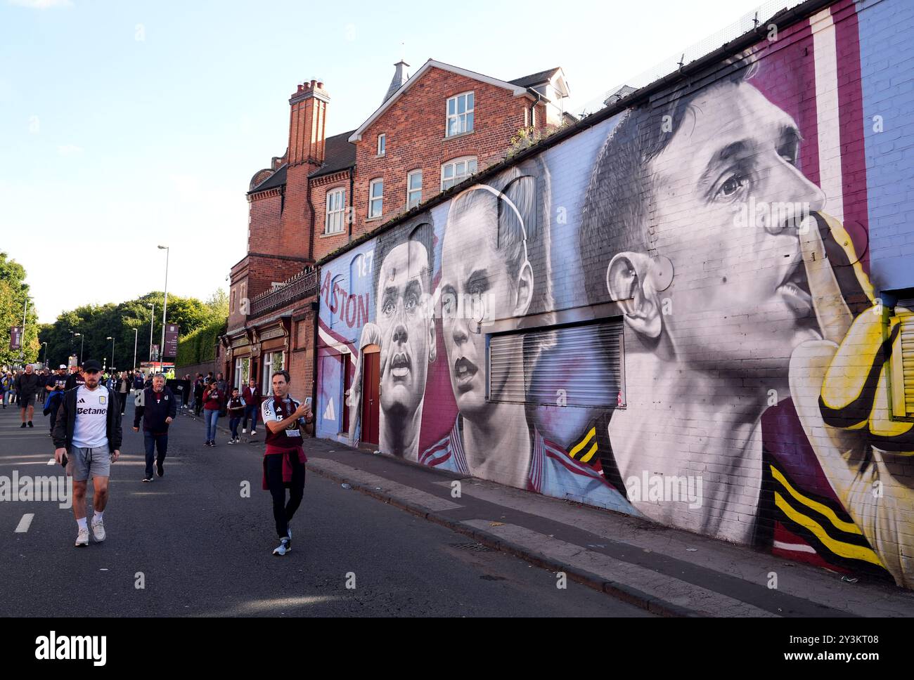 Fans with an Aston Villa mural featuring Ollie Watkins, Rachel Daly and Emiliano Martinez ahead ...