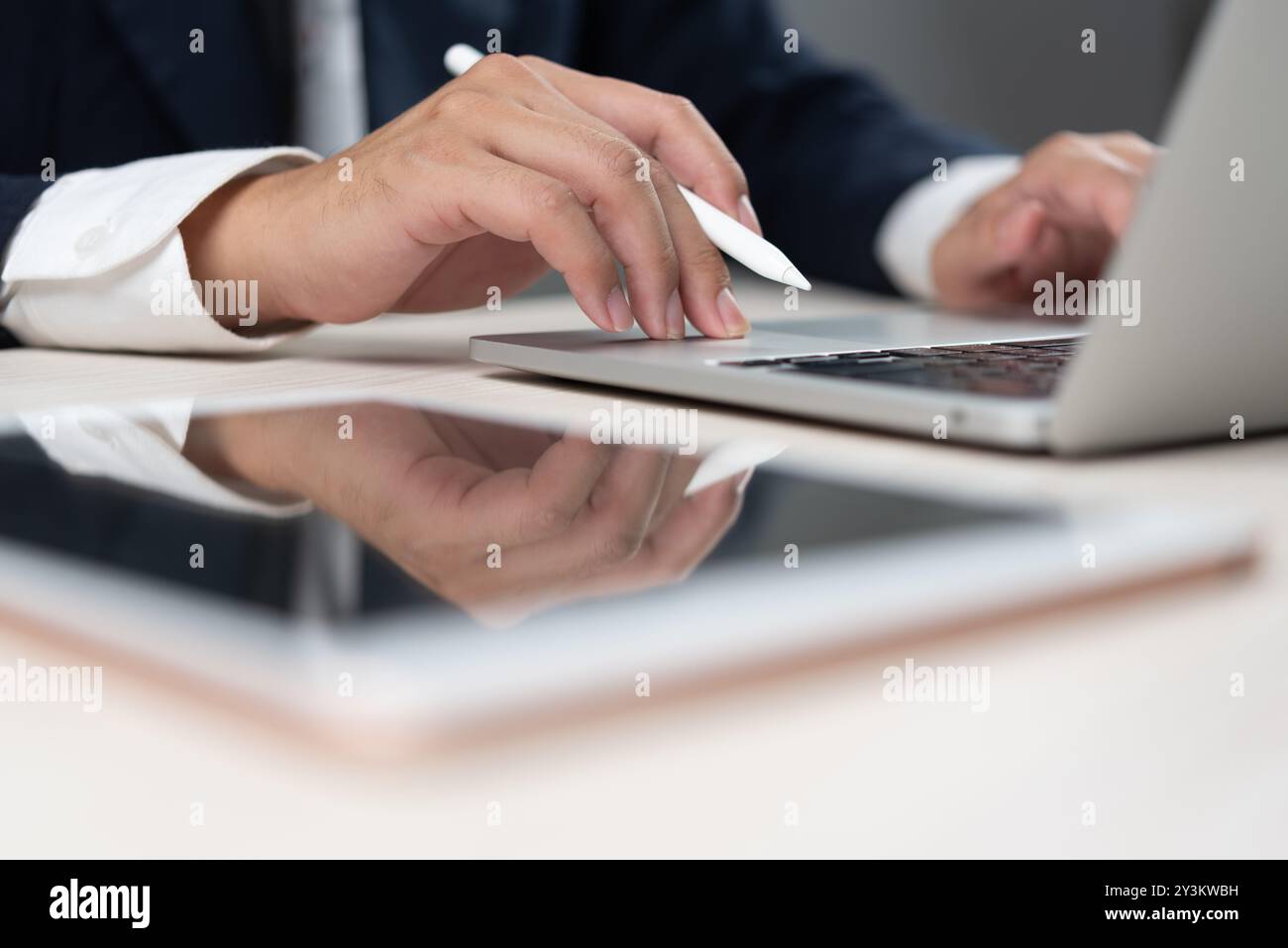 Businessman typing on a laptop with a stylus pen, representing ...