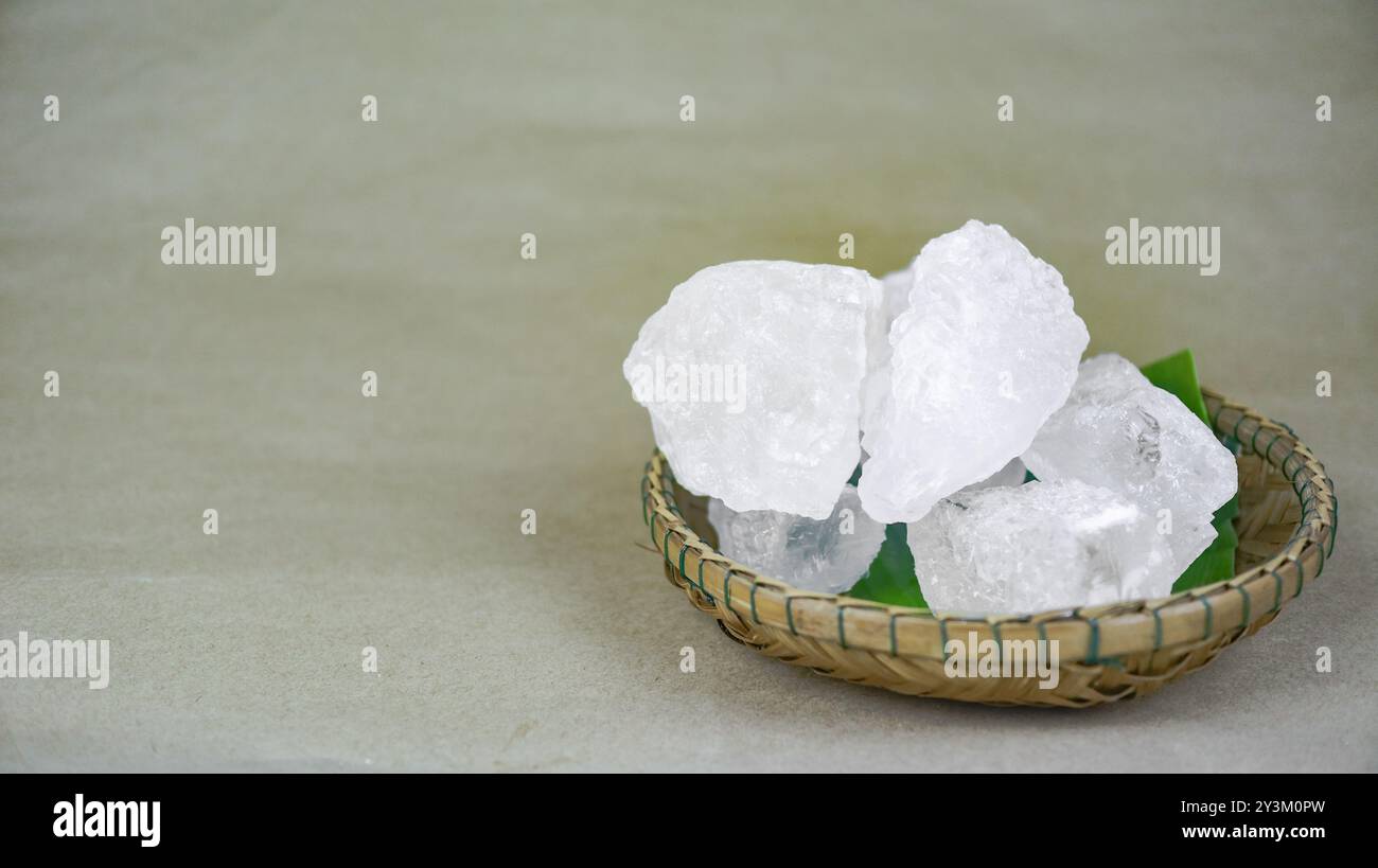 White crystal clear alum cube on brown background. The chemical ...