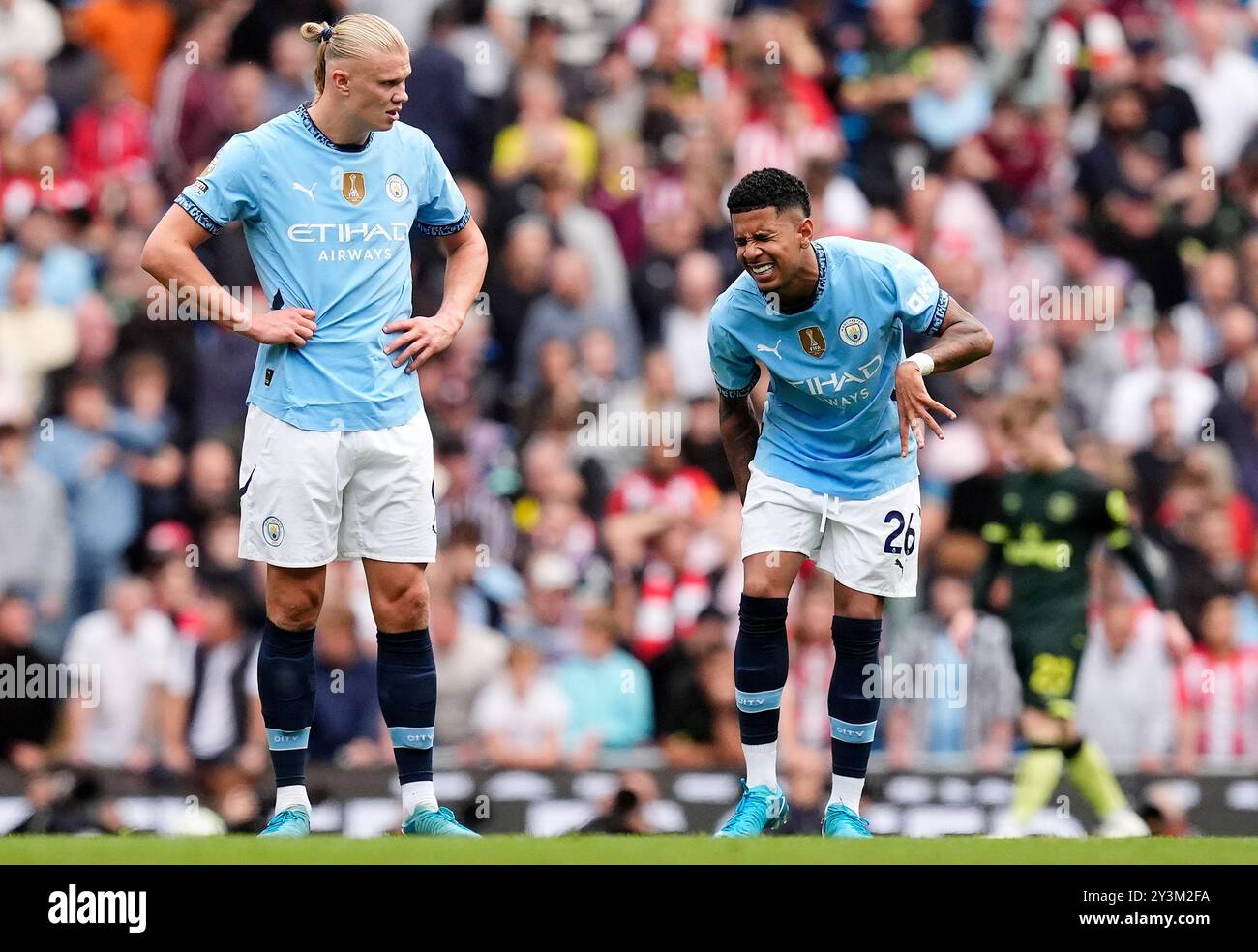 Manchester City's Savinho (right) reacts after picking up an injury ...
