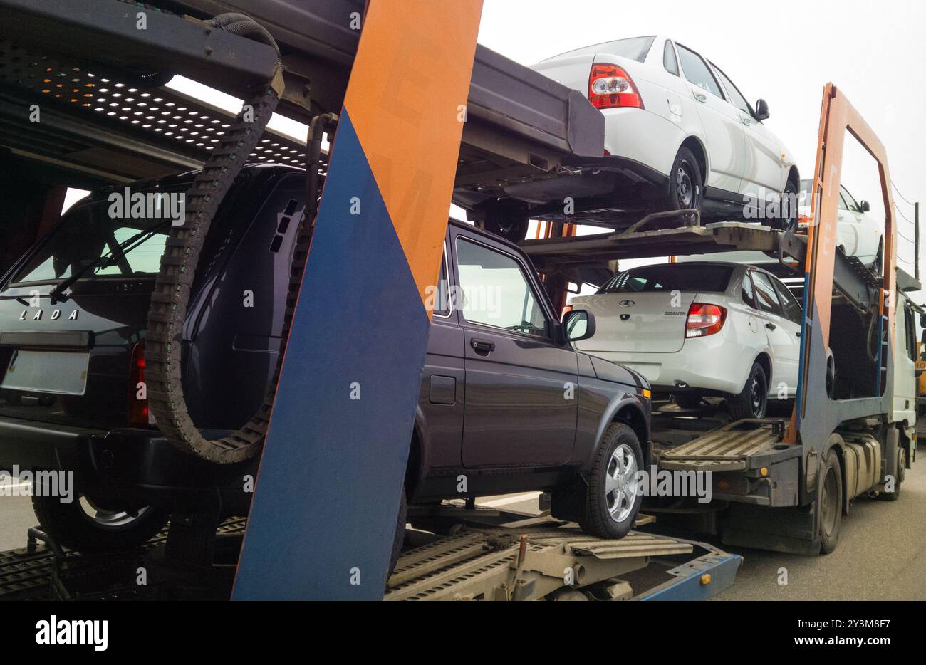 Russian automobles Lada are loaded into the car transportation trailer ...