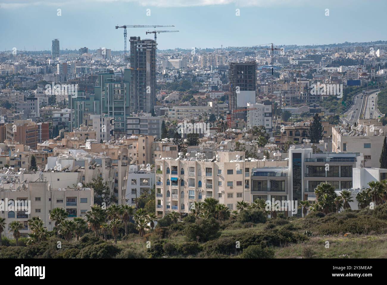 Construction cranes towering over Limassol city skyline showing urban ...