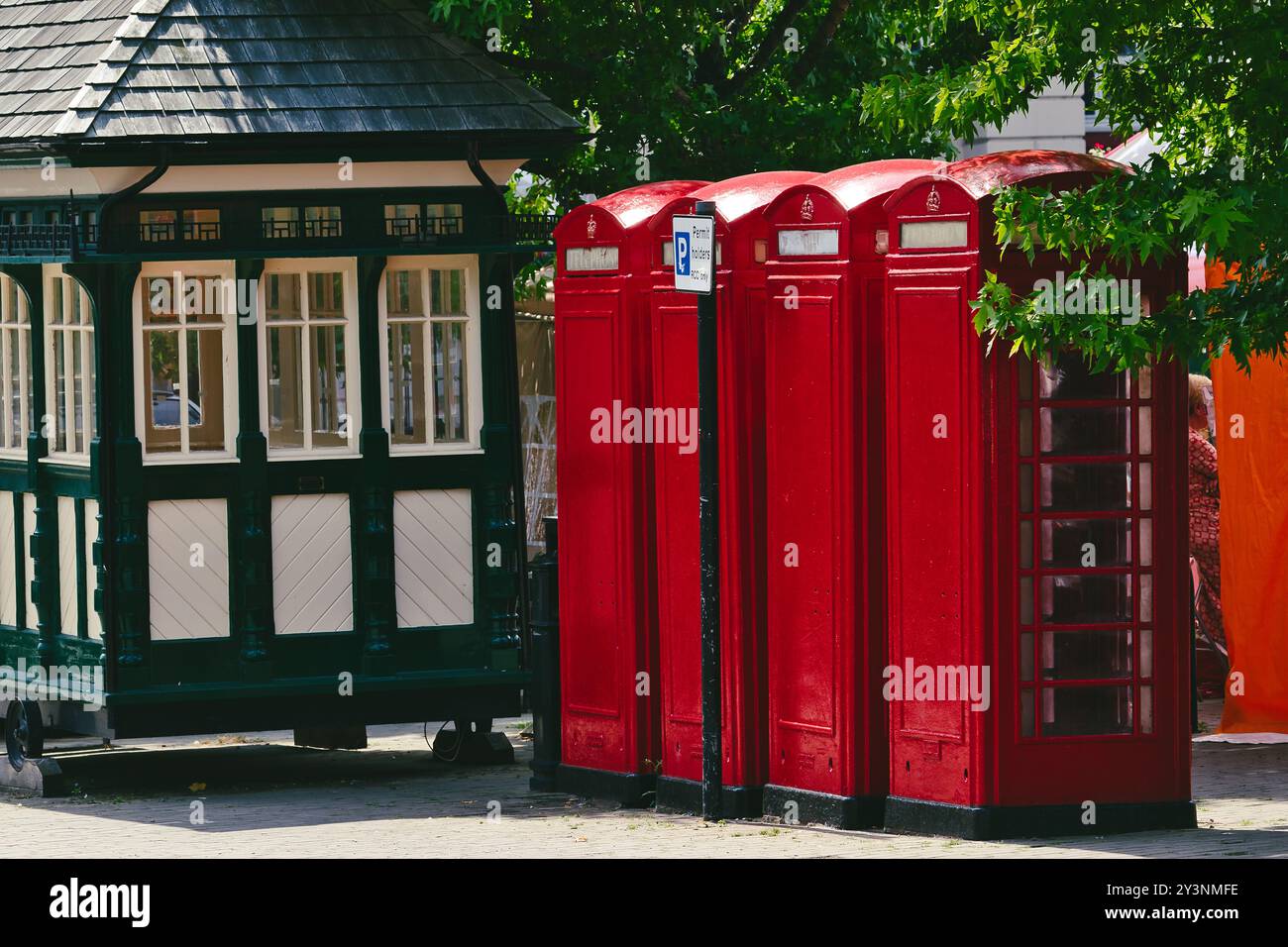A charming scene featuring three iconic red telephone booths next to a ...