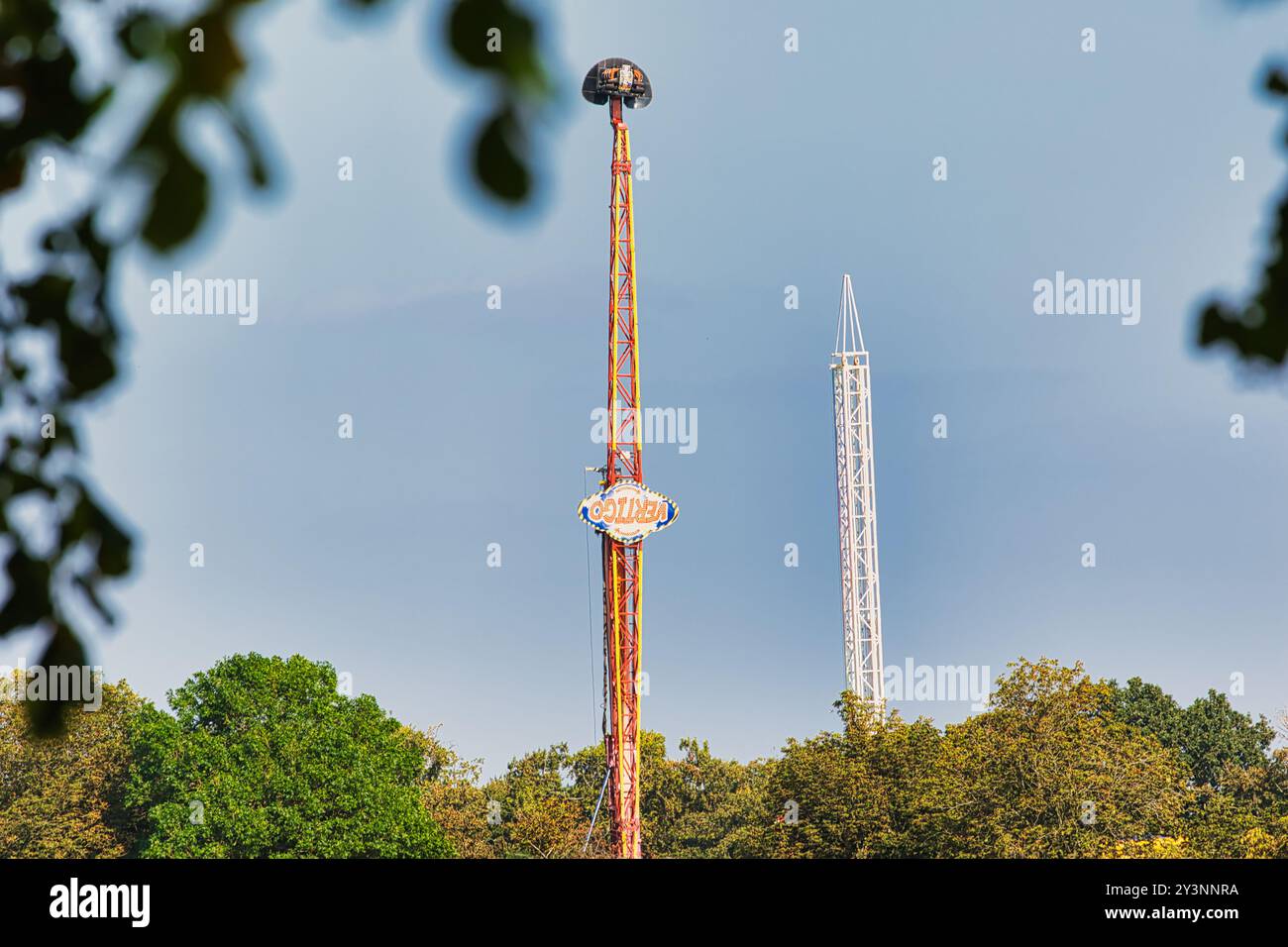 A tall amusement park ride, resembling a drop tower, stands prominently ...
