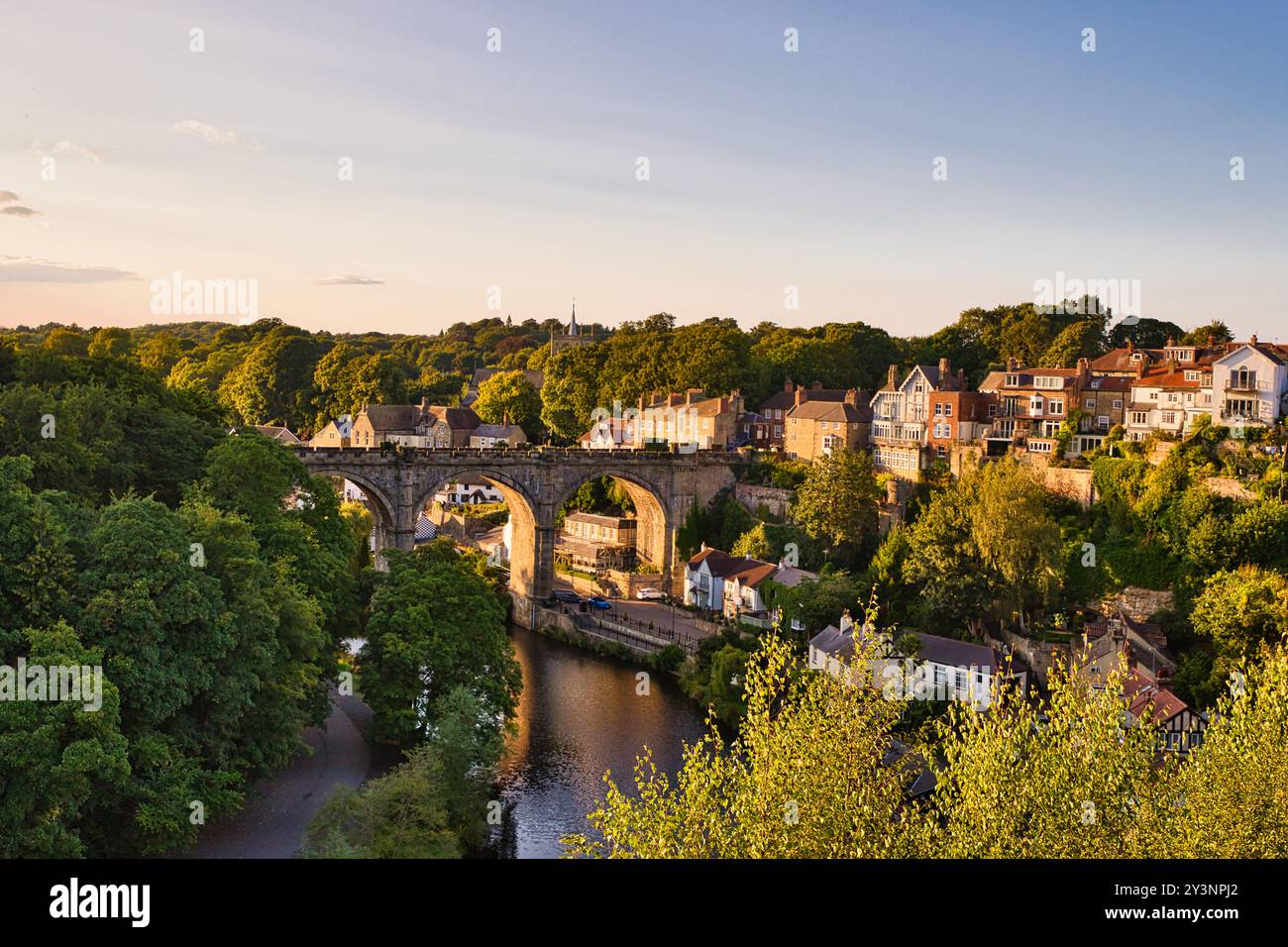A picturesque view of a stone bridge arching over a river, surrounded ...