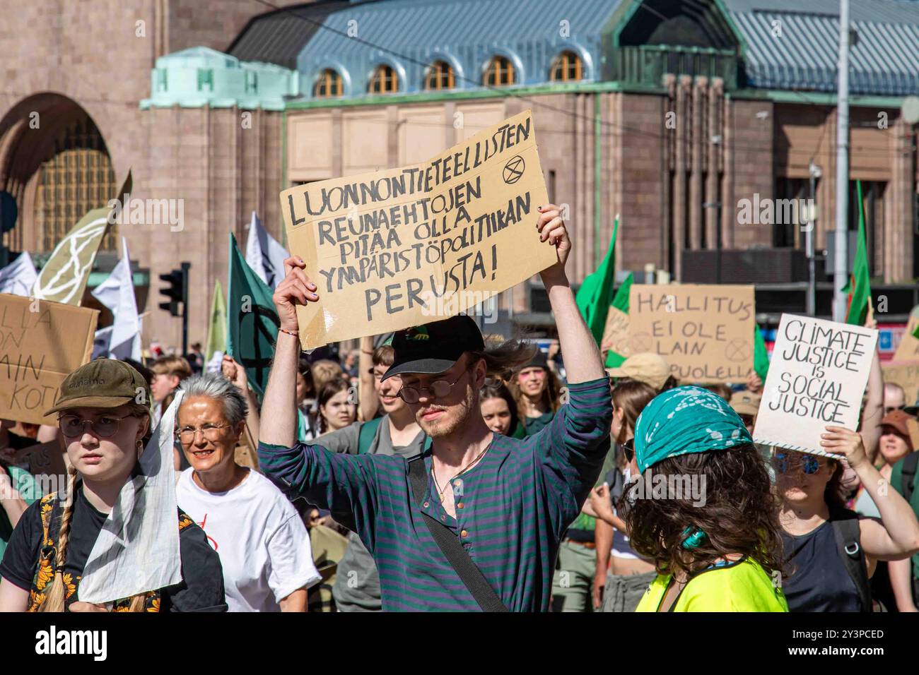 Protesters with handwritten signs at Elokapina's Myrskyvaroitus climate ...