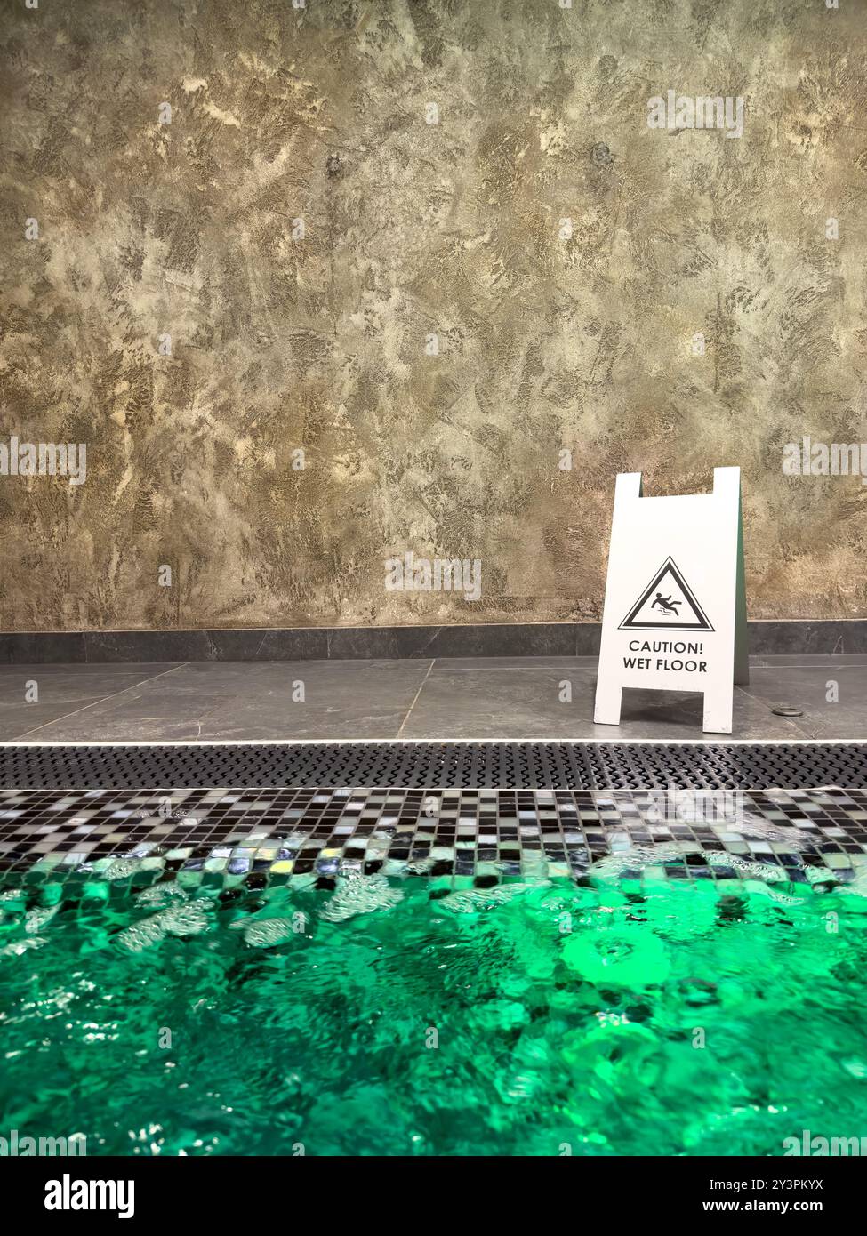 Vertical photo of Caution wet floor sign in the modern spa next to the ...