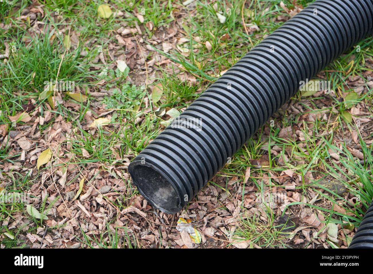 one black corrugated pipe lies on the ground Stock Photo - Alamy