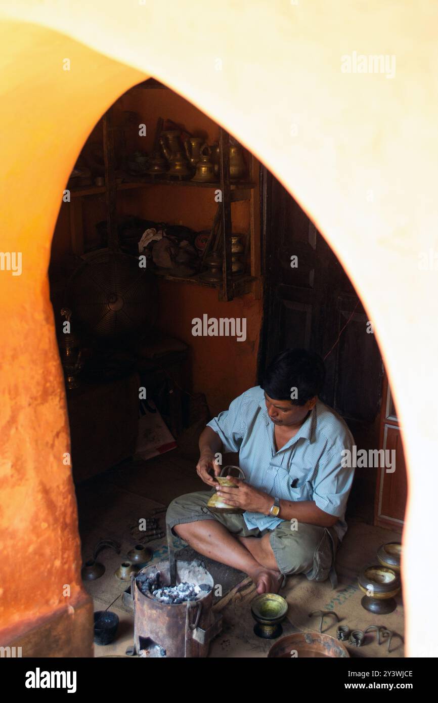 Tansen, Nepal. Nepali artisan sitting with legs crossed Stock Photo - Alamy