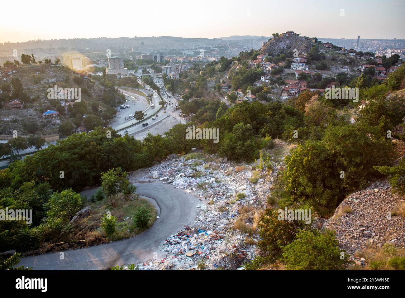 Urban-nature divide: Lush greenery and rocky terrain frame a bustling ...