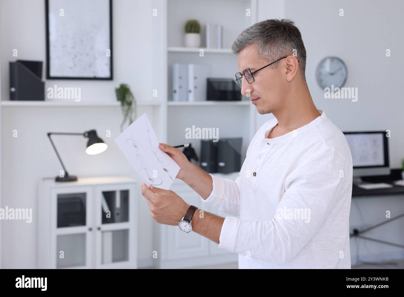 Architect holding paper sheet with engineering drawing in office Stock ...