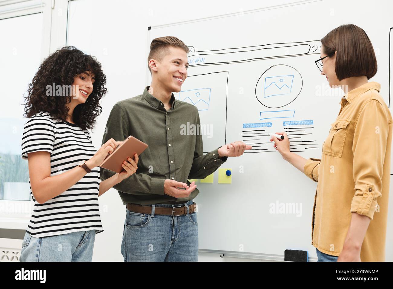 Developing UI design. People drawing website wireframe on whiteboard ...
