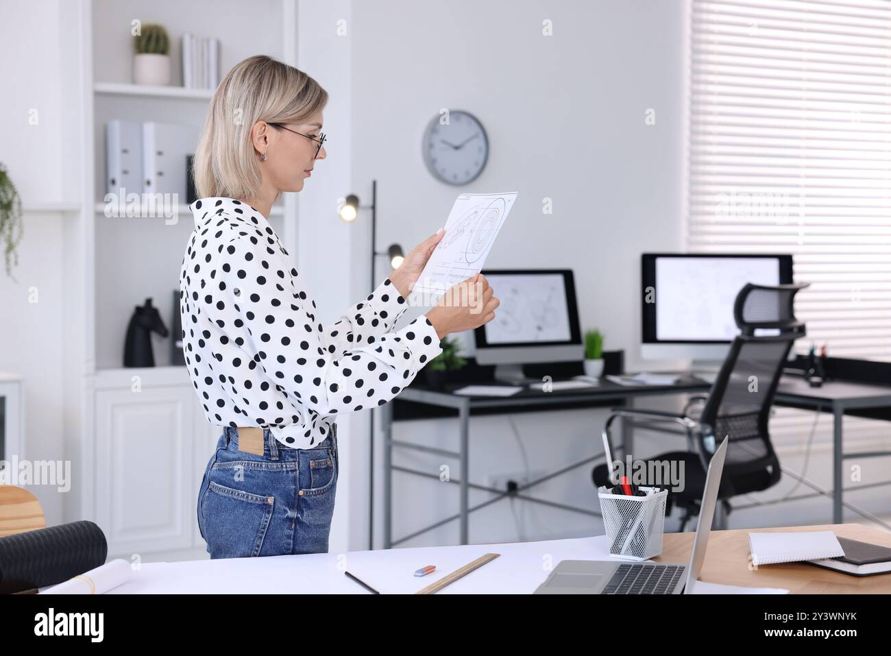 Architect holding paper sheet with engineering drawing in office Stock ...