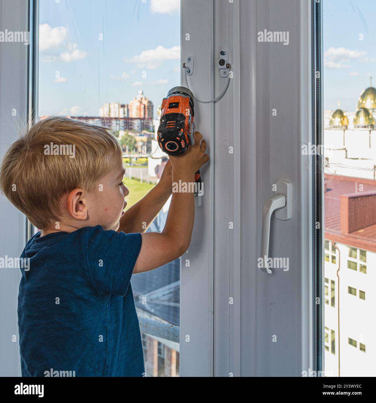 A little boy helps his dad install a lock for his safety Stock Photo ...