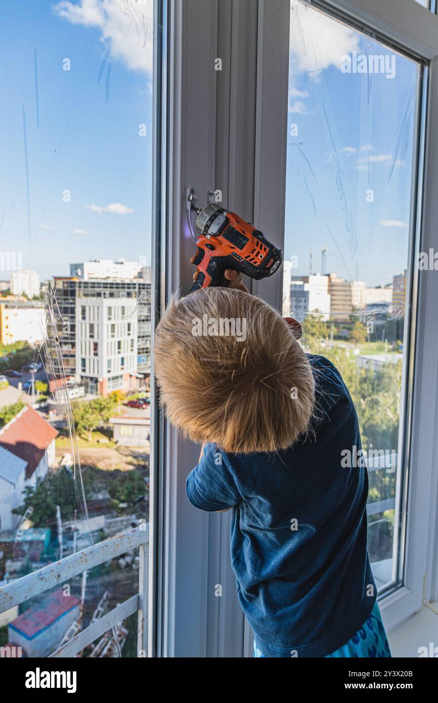 A little boy helps his dad install a lock for his safety Stock Photo ...