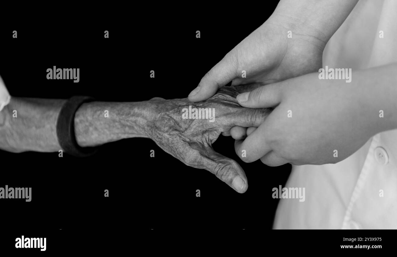 Young hands holding an old woman's wrinkled hands Stock Photo - Alamy