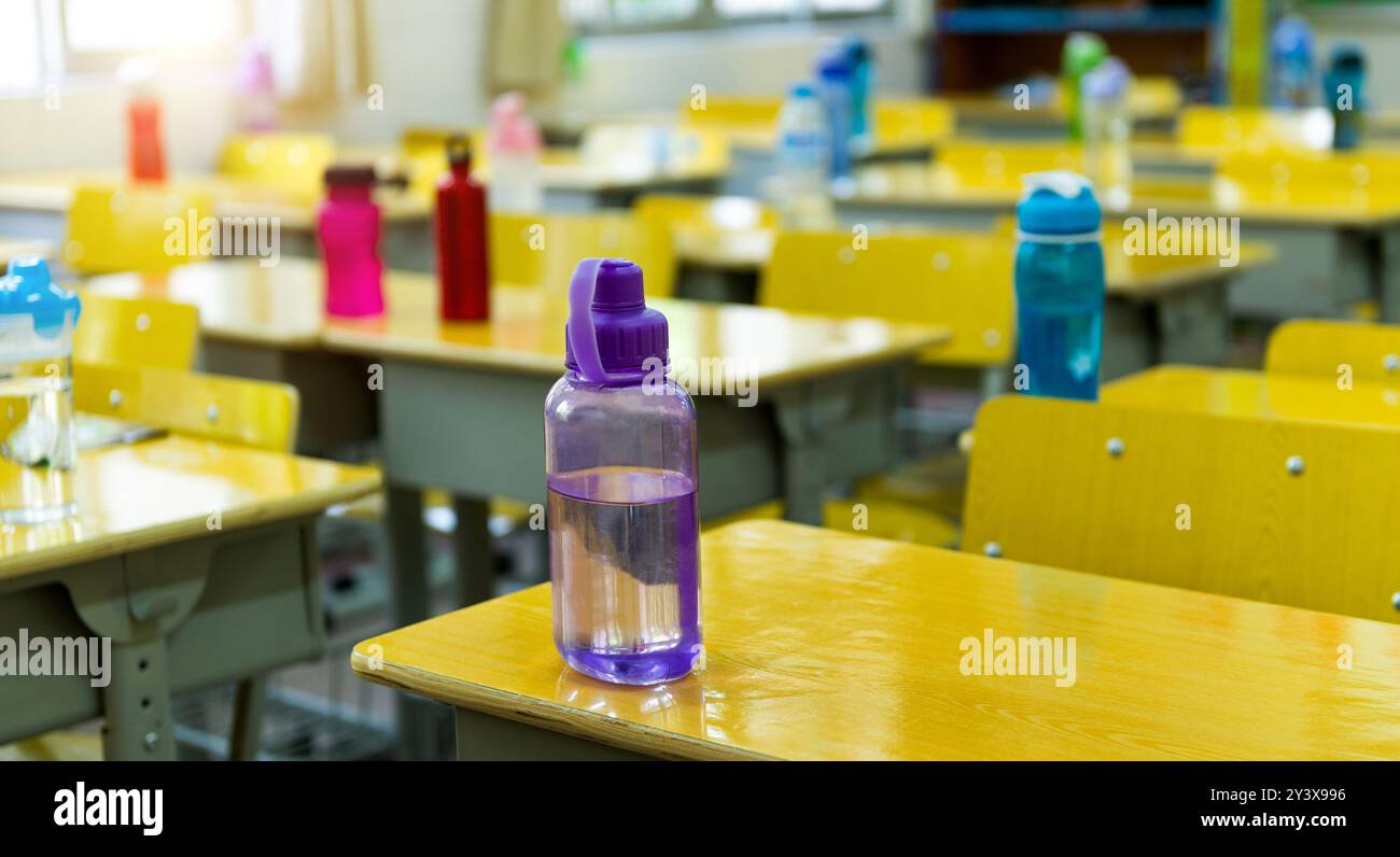 Bottles of water on desk in classroom Stock Photo - Alamy