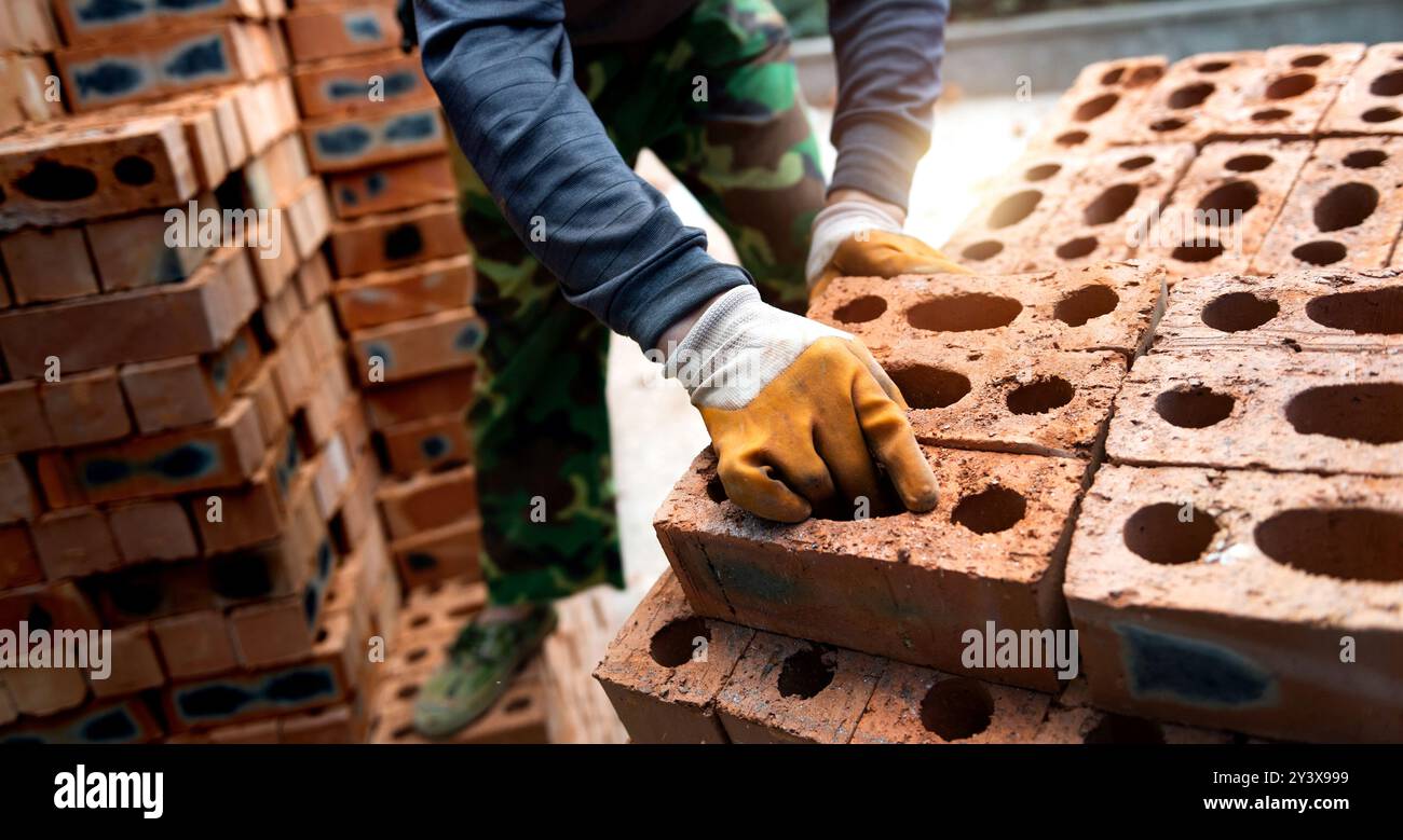 Bricklayer with brick at construction site Stock Photo - Alamy