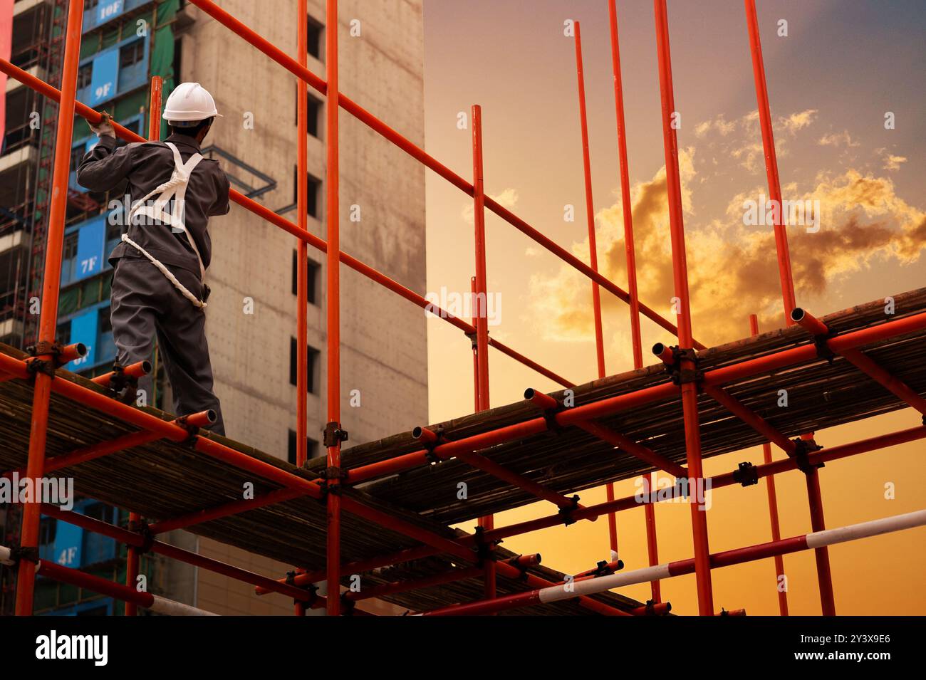 Single construction worker working on scaffolding Stock Photo - Alamy
